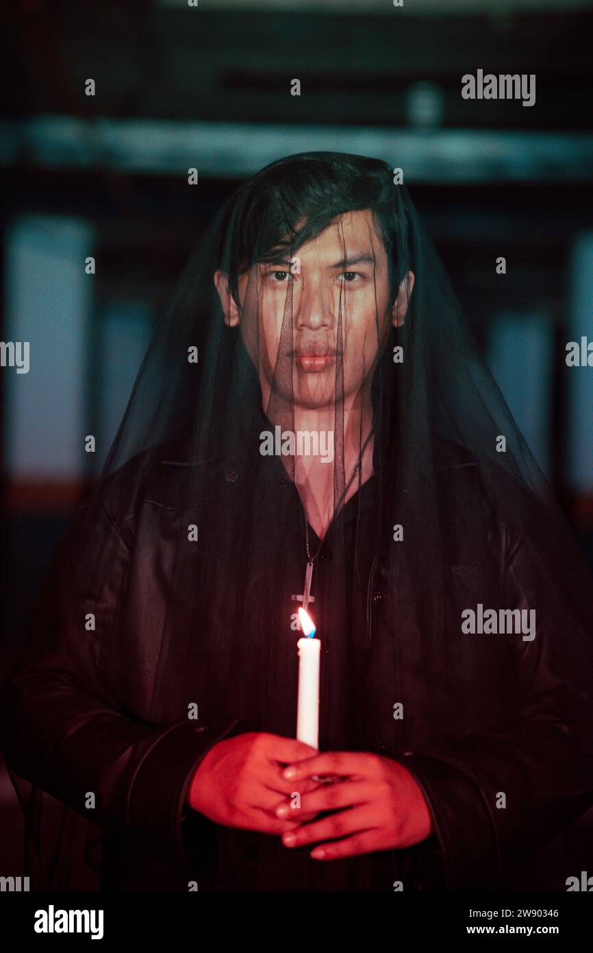a male devil worshiper with a transparent veil is performing a spooky ...