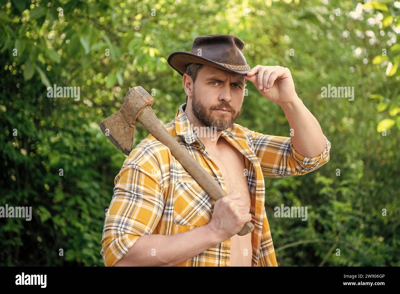 cowboy with axe in hat outdoor. photo of cowboy with axe. cowboy with ...