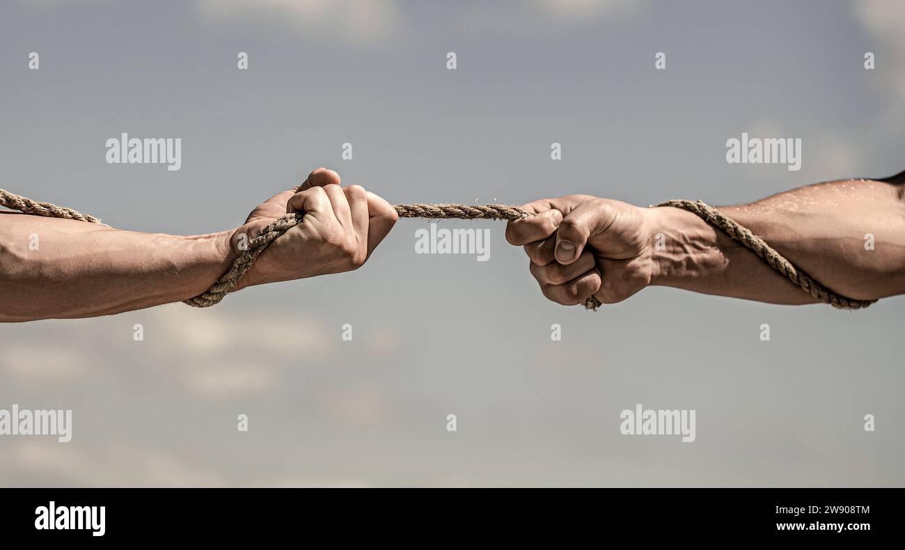 Conflict tug of war. Hand holding a rope, climbing rope, strength and determination. Rescue ...