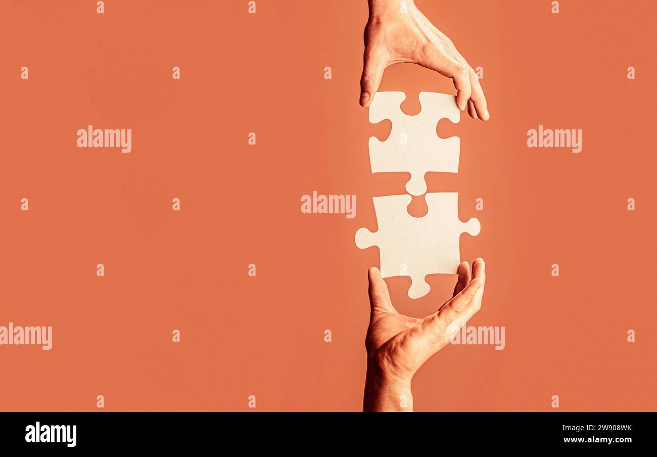 Closeup hands of man connecting jigsaw puzzle. Two hands trying to ...