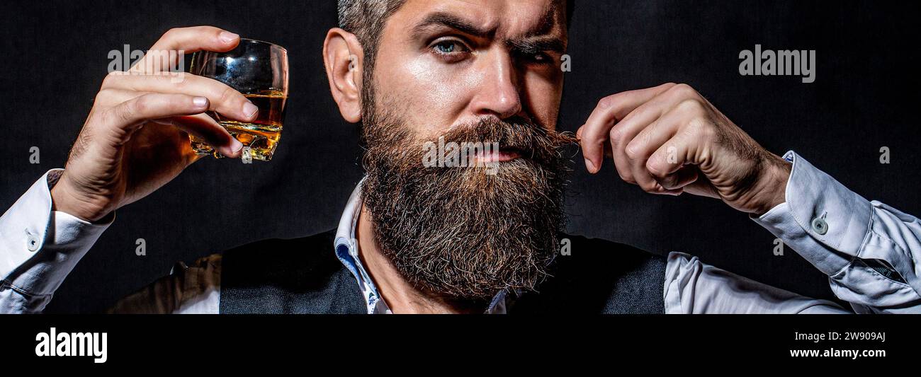 Man with beard holds glass of brandy. Tasting and degustation concept ...