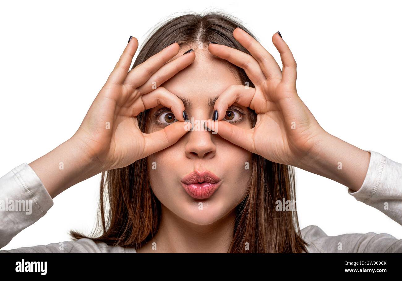 Pretty girl surprised face holding fingers near eyes like glasses. Girl ...