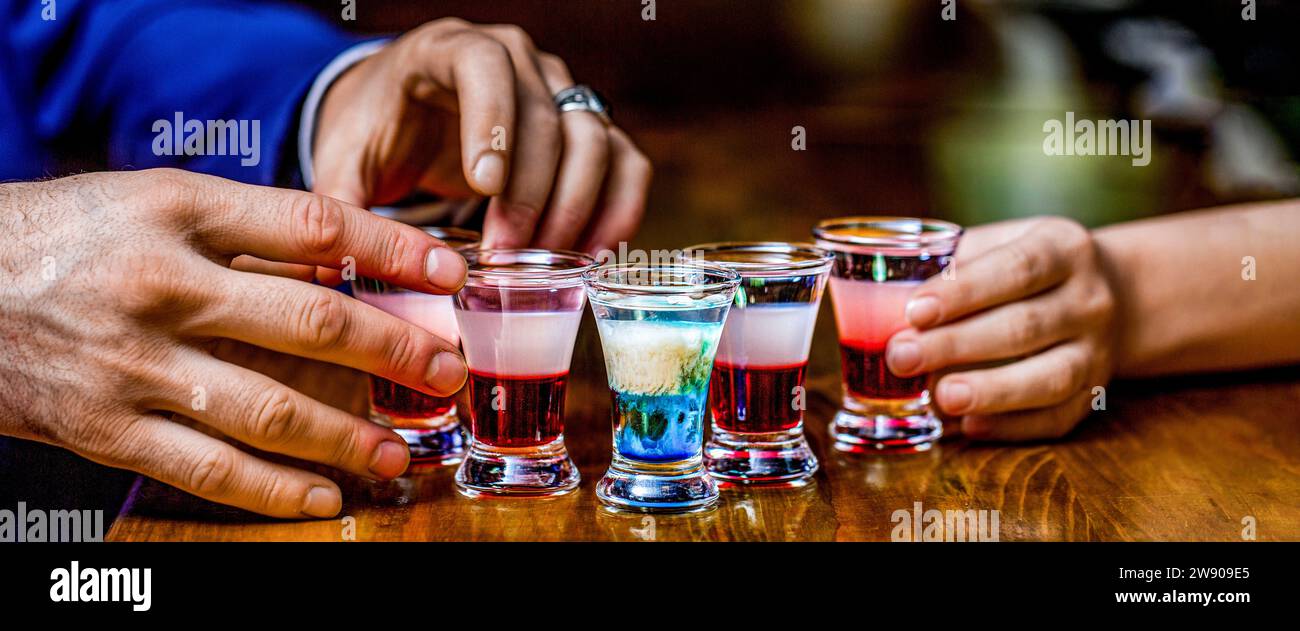 Man hands glasses of shot or liqueur. Glasses of alcohol. Tequila shots ...