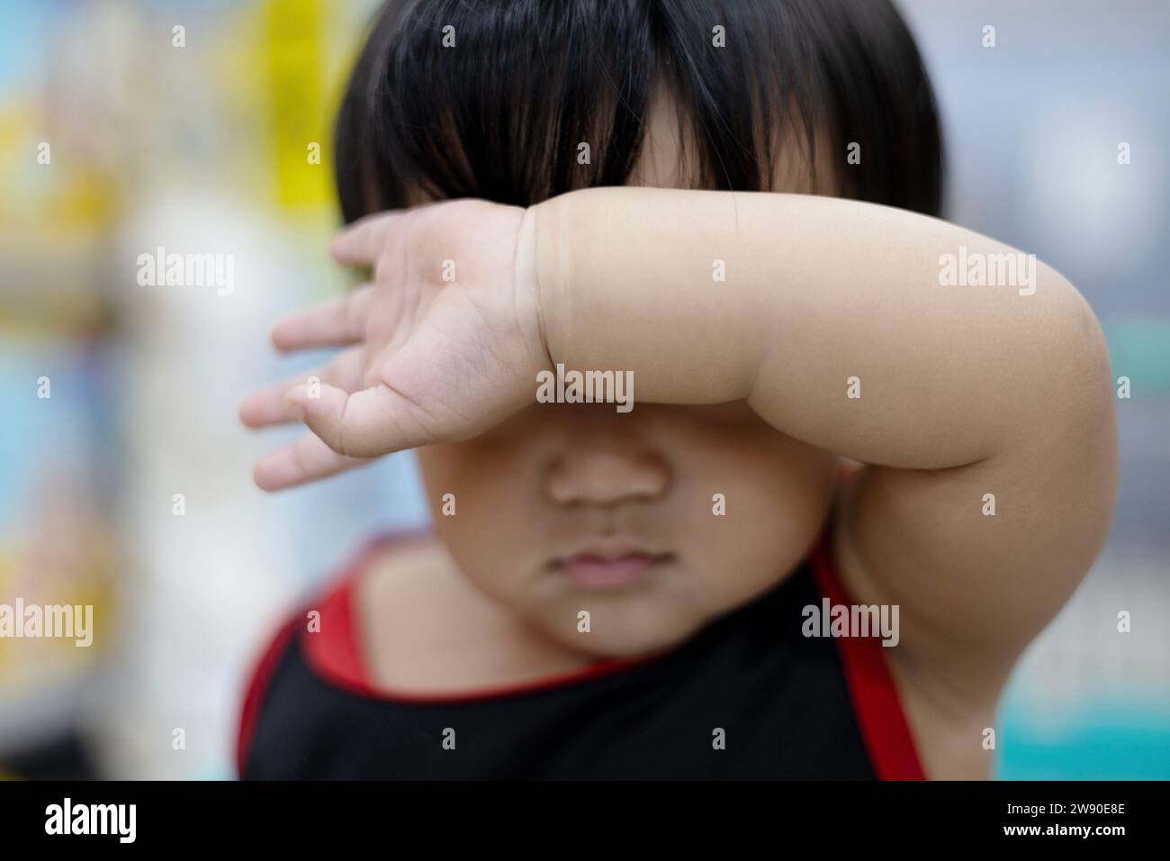 Cute boy holding his right arm on the front as protecting from sun. Boy ...
