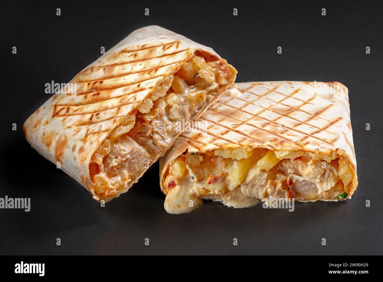 French tacos with grilled chicken. Cut French Tacos close up on black ...