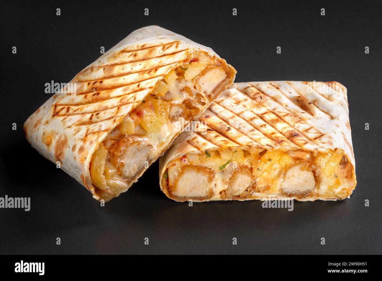 French tacos with chicken popcorn. Cut French Tacos close up on black ...