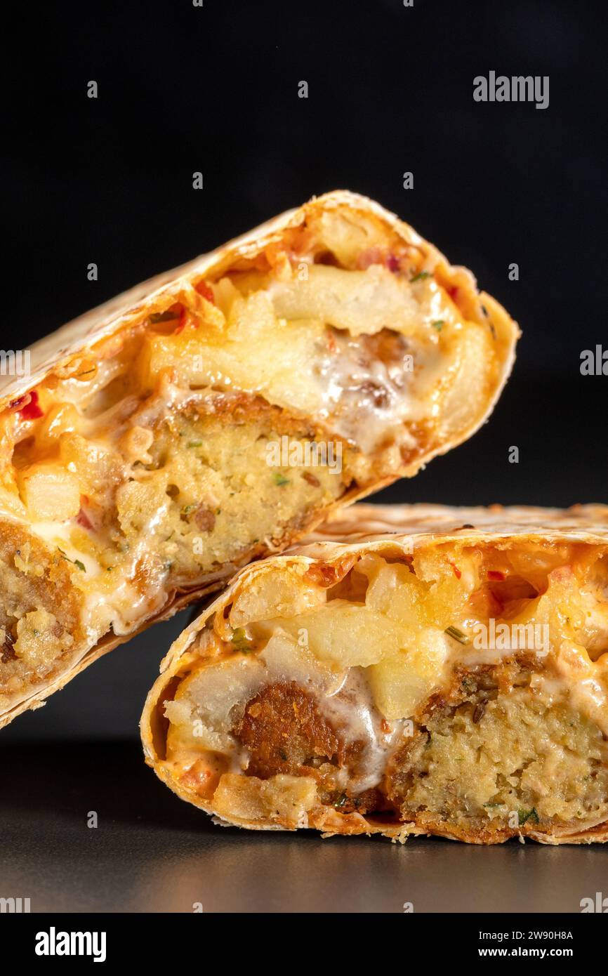 French tacos with Falafel. Cut French Tacos close up on black ...