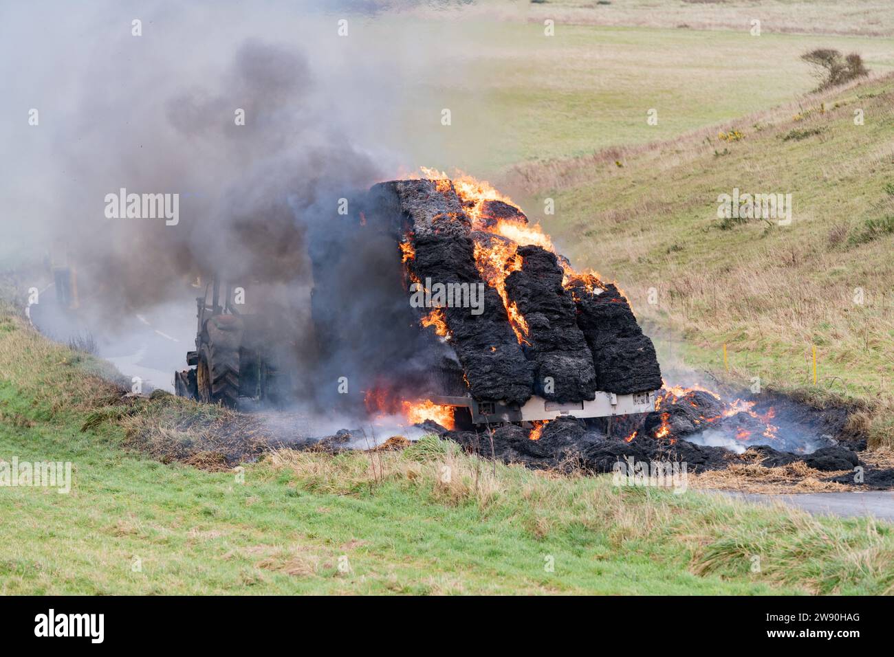 A tractor pulling a trailer full of bales of hay burst into flames by ...
