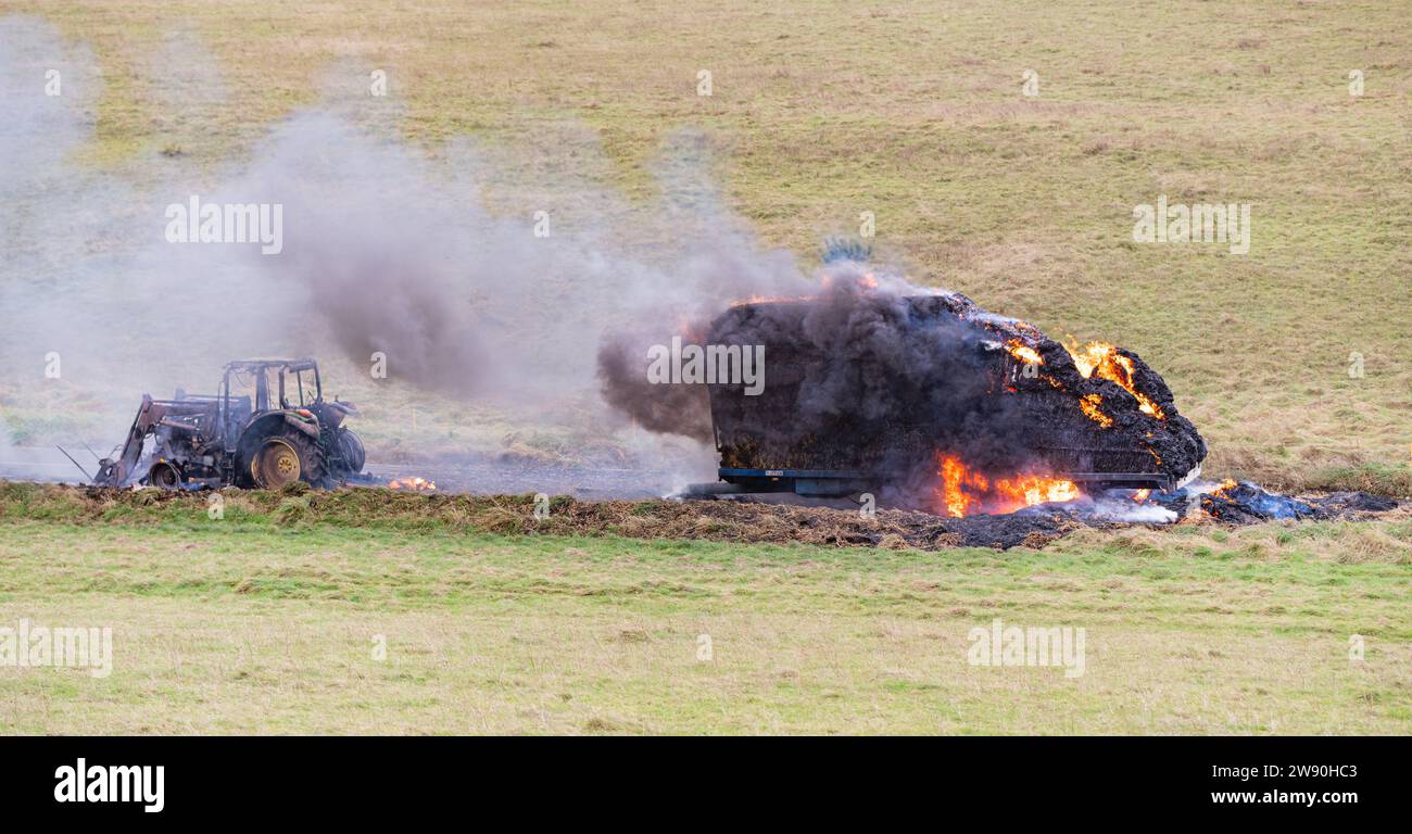 A tractor pulling a trailer full of bales of hay burst into flames by ...