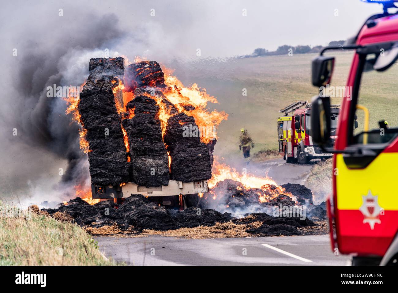 A tractor pulling a trailer full of bales of hay burst into flames by ...