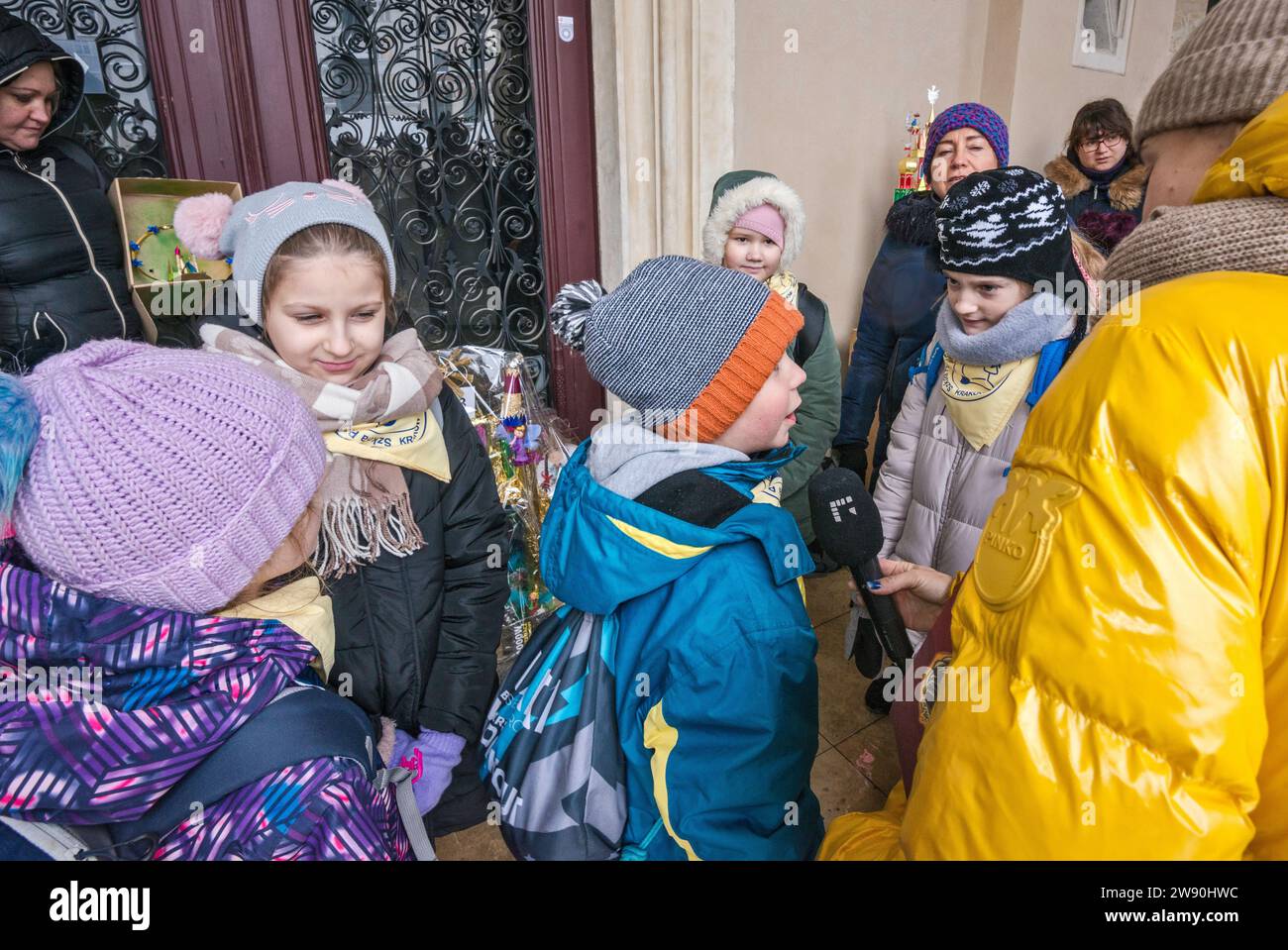 Reporter interviewing children near Szopka (Christmas Nativity scene ...
