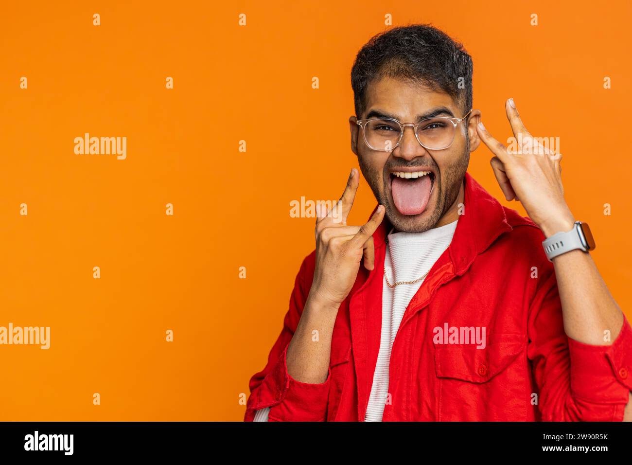 Overjoyed happy excited Indian man showing rock n roll gesture by hands ...