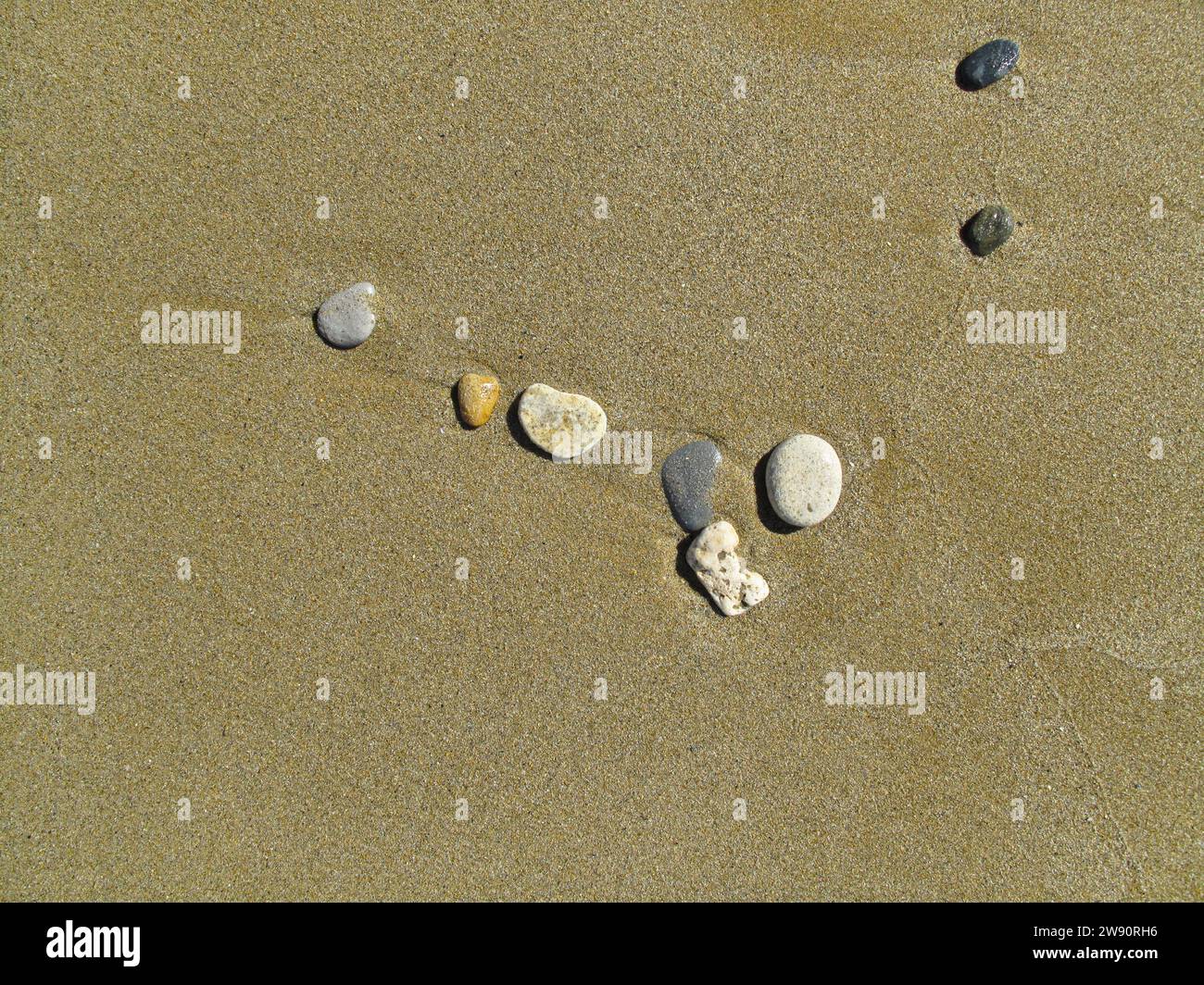 Wet sand background with sea pebbles Stock Photo - Alamy
