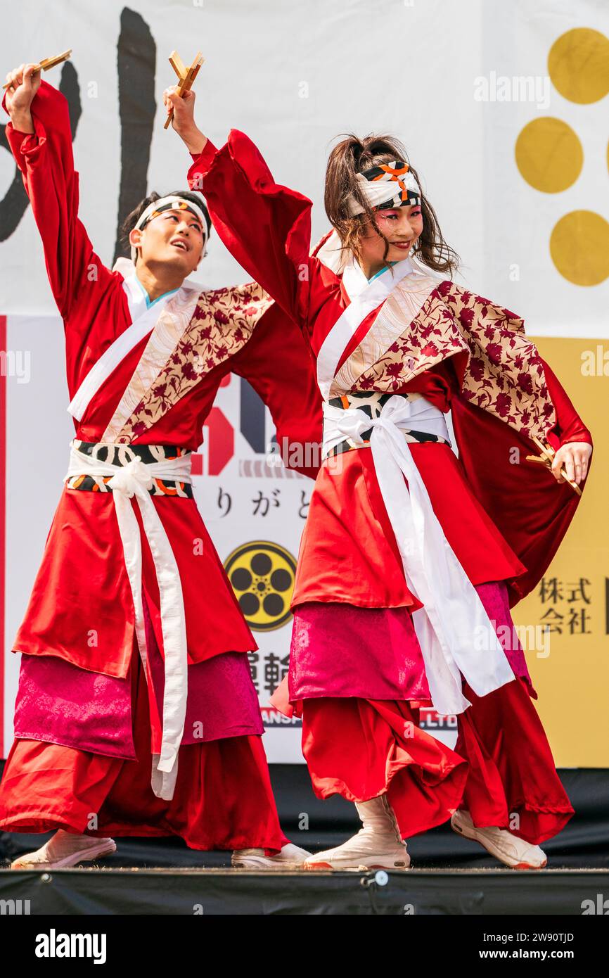 Close up, young Japanese woman and man yosakoi dancers on stage dancing ...