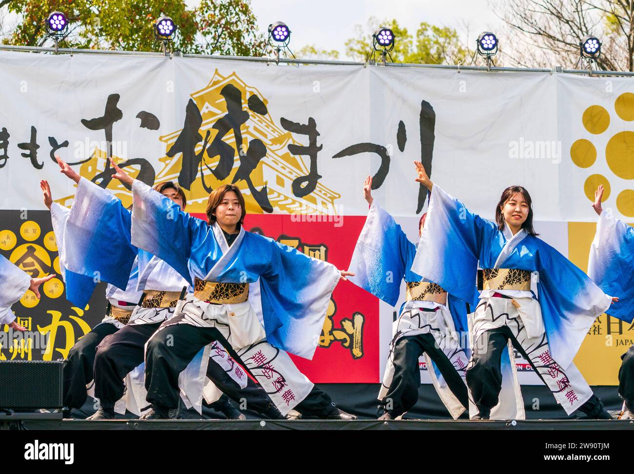 Four Japanese yosakoi dancers on stage with their arms outstretched ...