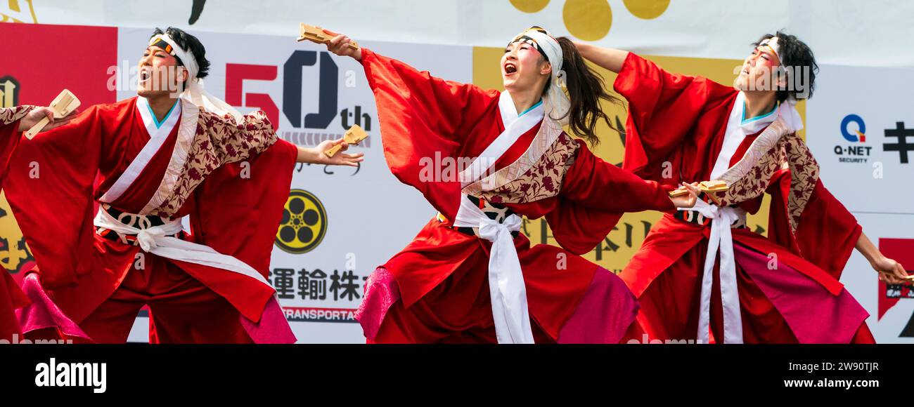 Team of Japanese yosakoi dancers on stage dancing in red skirts and ...