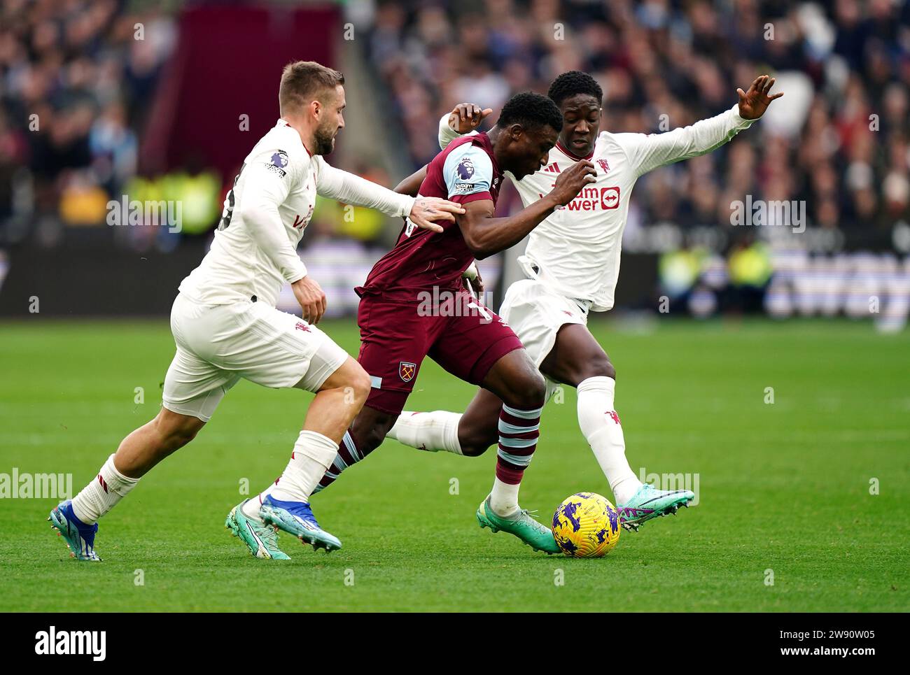 West Ham United's Mohammed Kudus runs between Manchester United's Luke ...