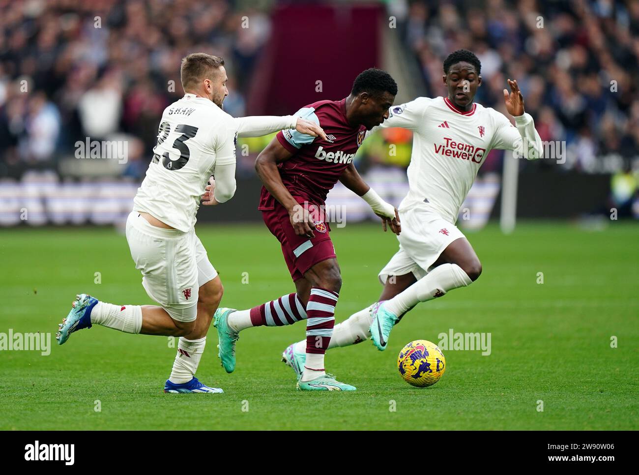 West Ham United's Mohammed Kudus runs between Manchester United's Luke ...