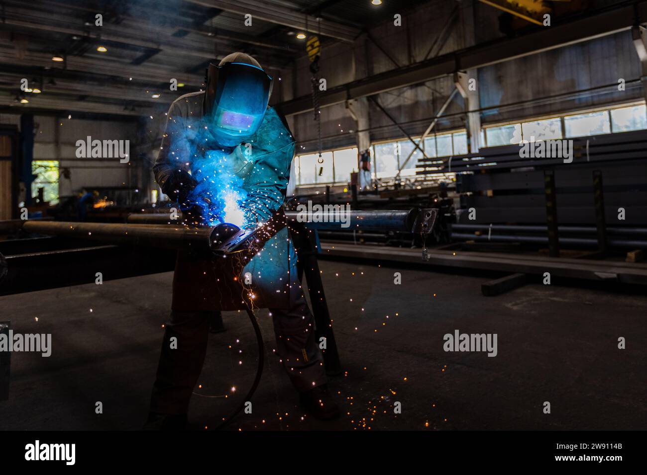 The welder works in the workshop. The moment of welding of metal ...