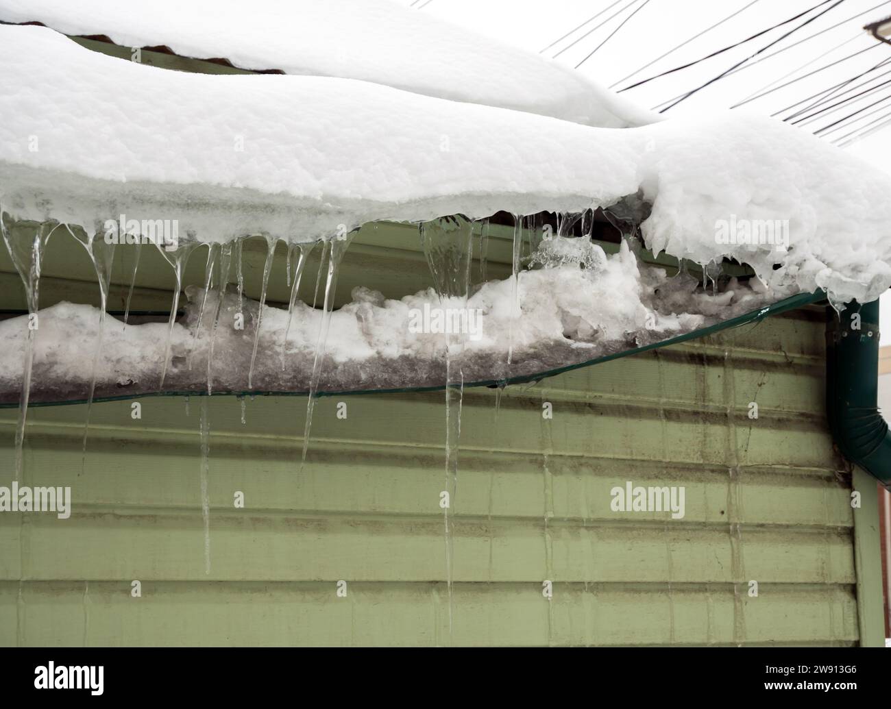 Gutter broken by snow masses sliding from the roof Stock Photo - Alamy