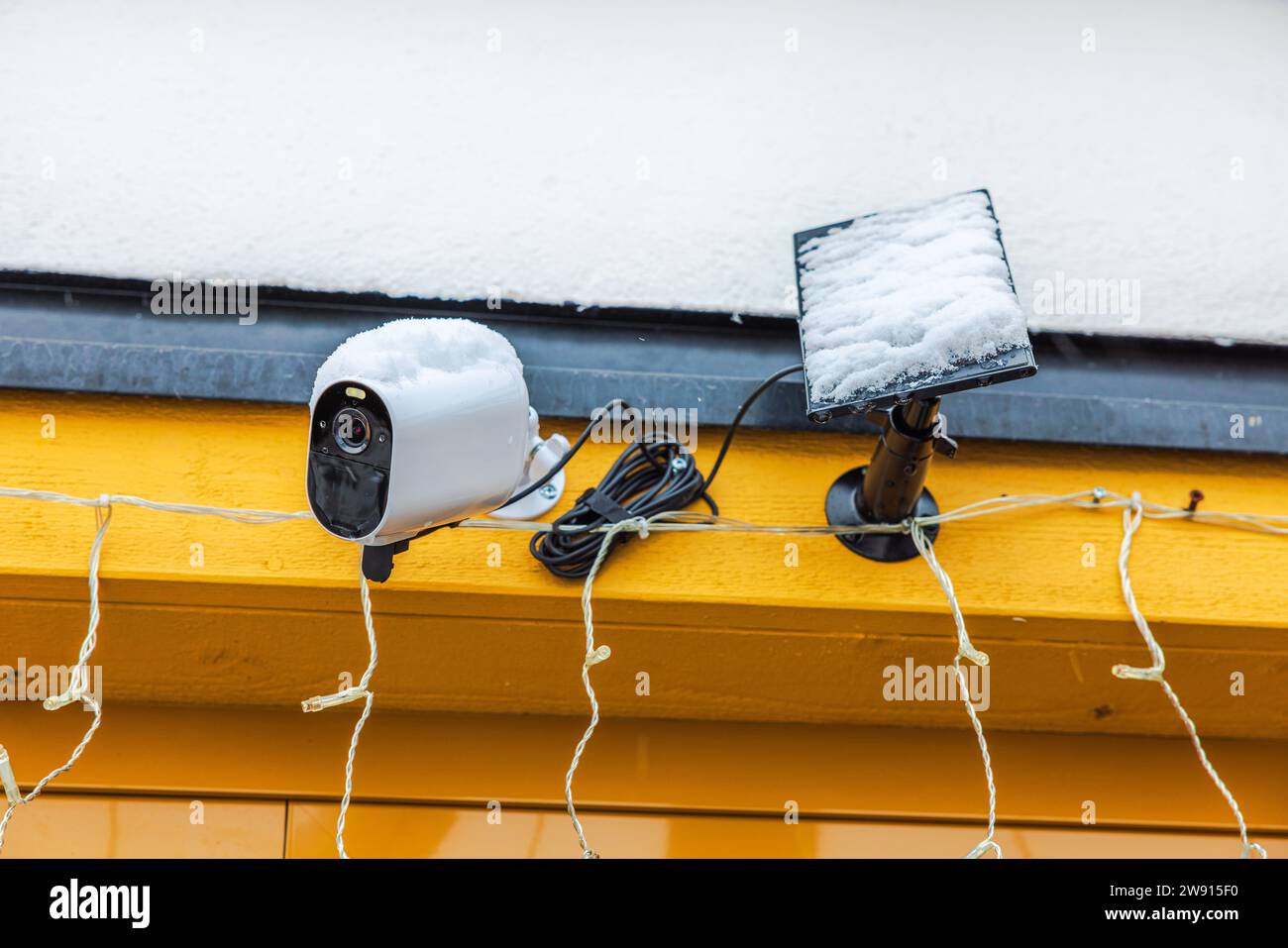 Close-up view of outdoor surveillance with a snow-covered solar panel ...