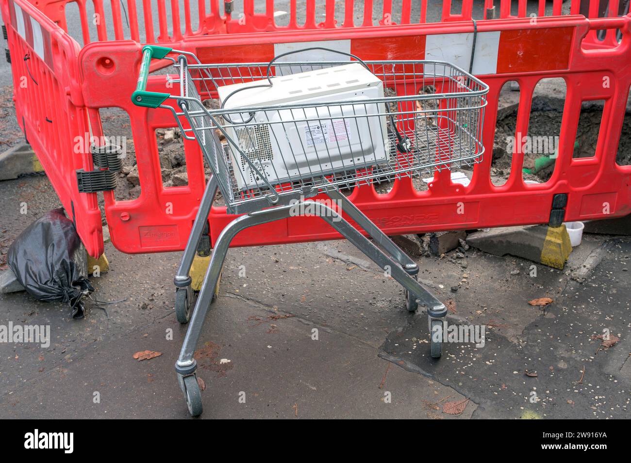 Dumped microwave oven ovens in a shopping trolley trolleys hi-res stock ...