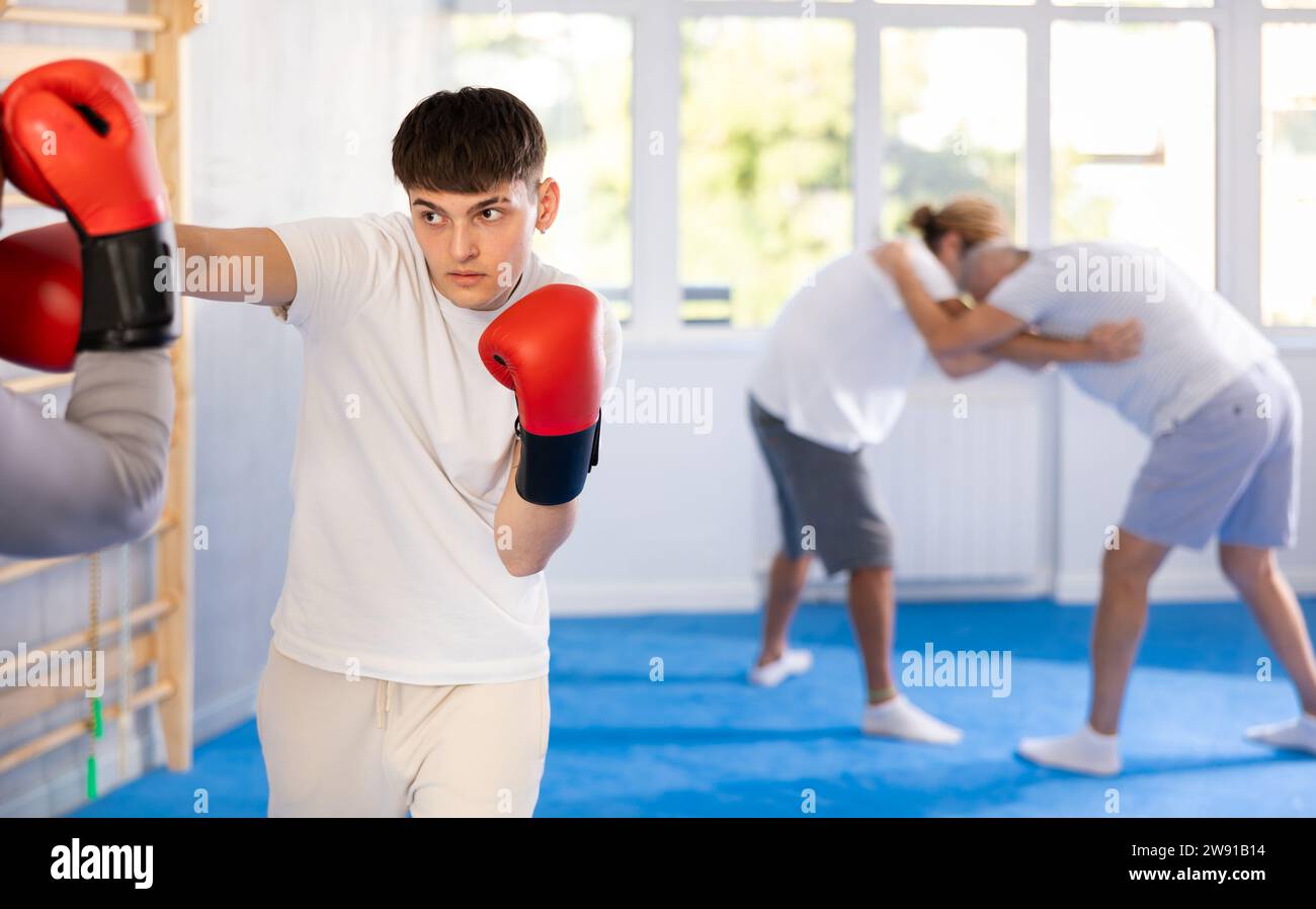 Two men in boxing training perform sparring and one man blocked blow ...