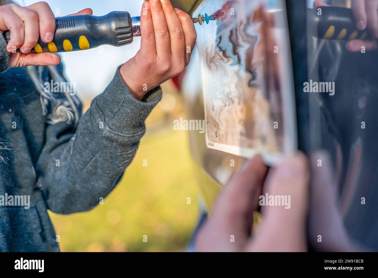 Using a screw driver to remove and replace a vehicle rear license plate ... Using a screw driver to remove and replace a vehicle rear license plate ...