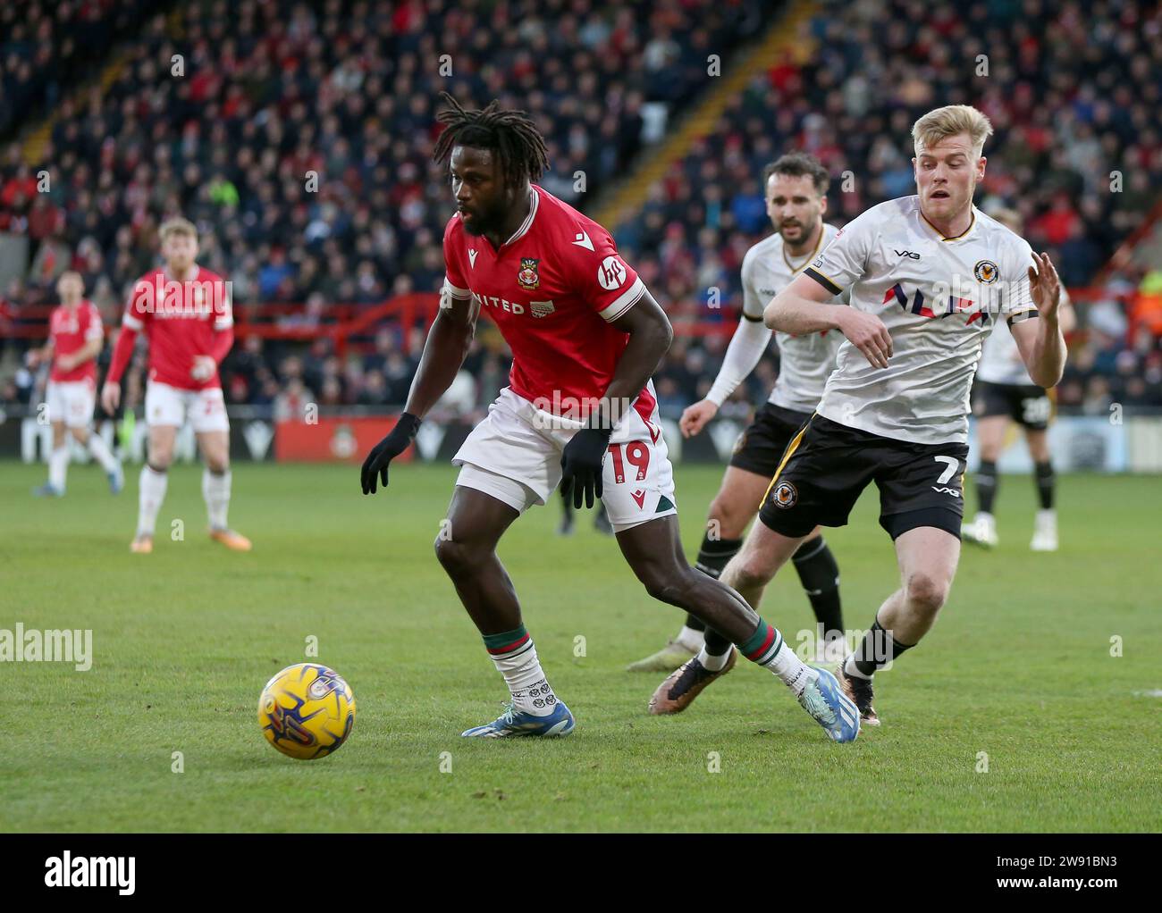 Wrexham’s Jacob Mendy (left) and Newport County’s Will Evans battle for ...