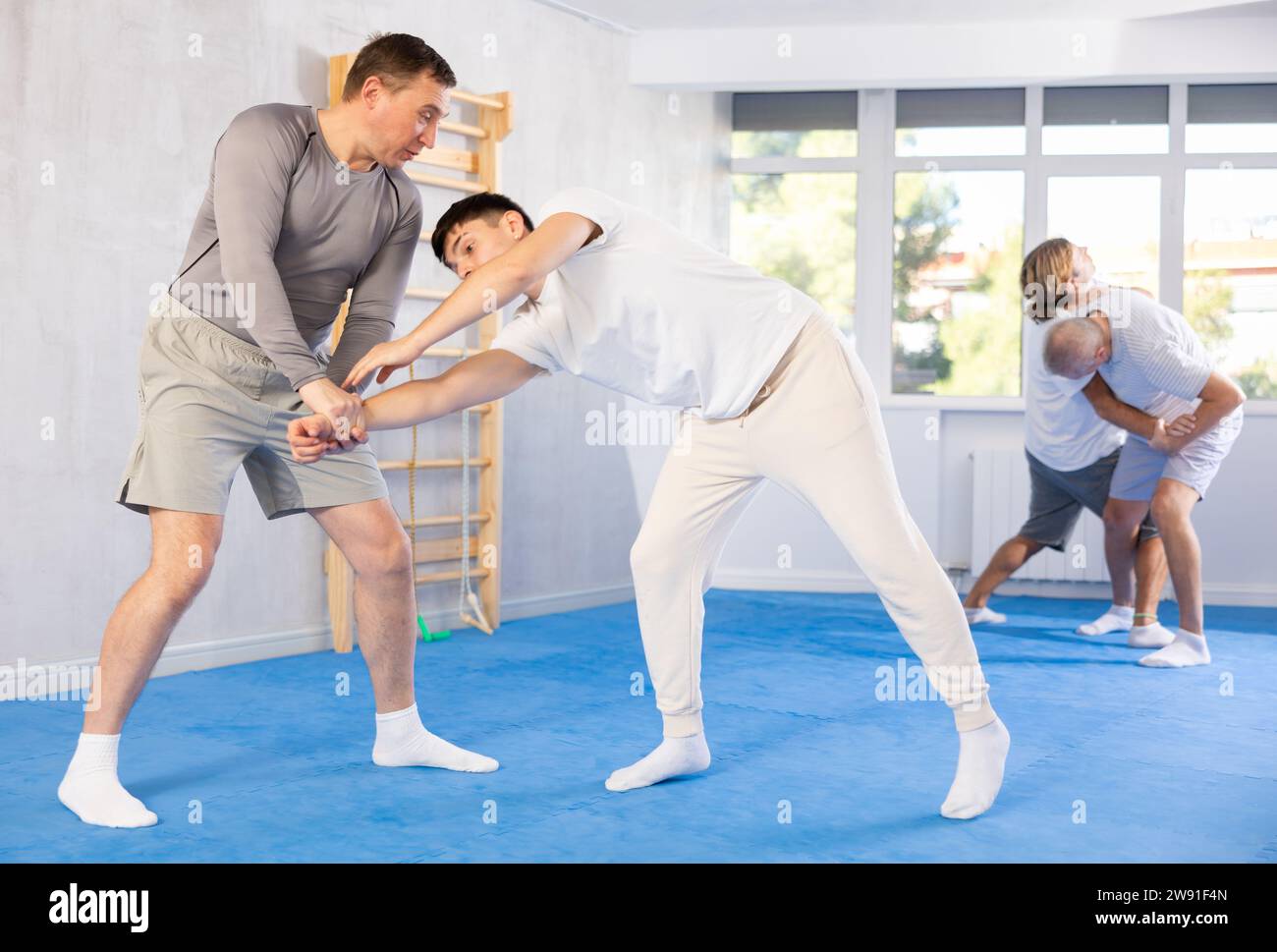 Young guy and man practice wrestling, apply techniques of Aikido and ...