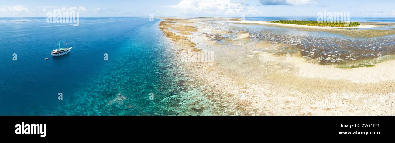 Clear water bathes a coral reef fringing the remote island of Koon near ...