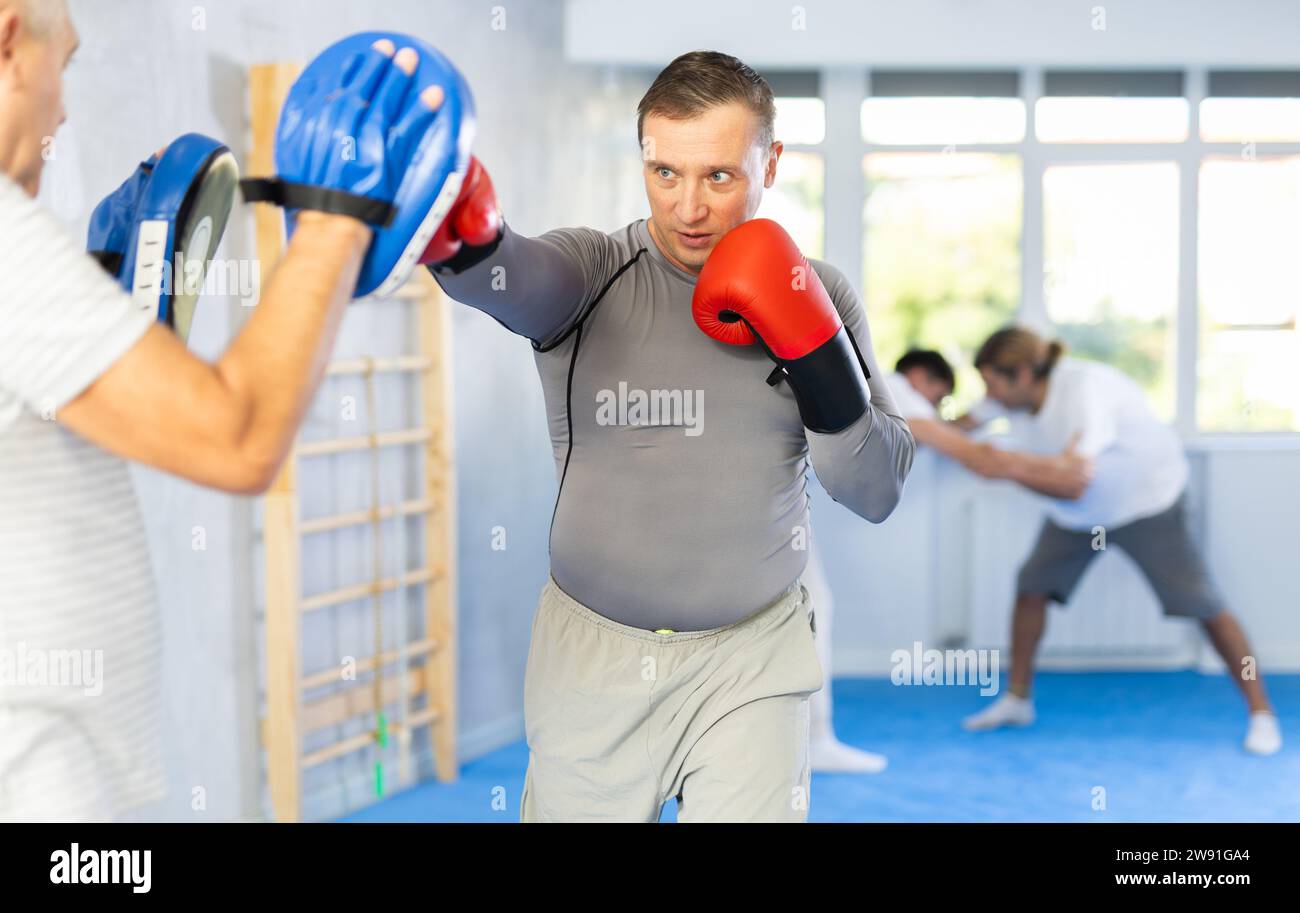 Man works out strength and speed of boxing punch mitts with help of ...