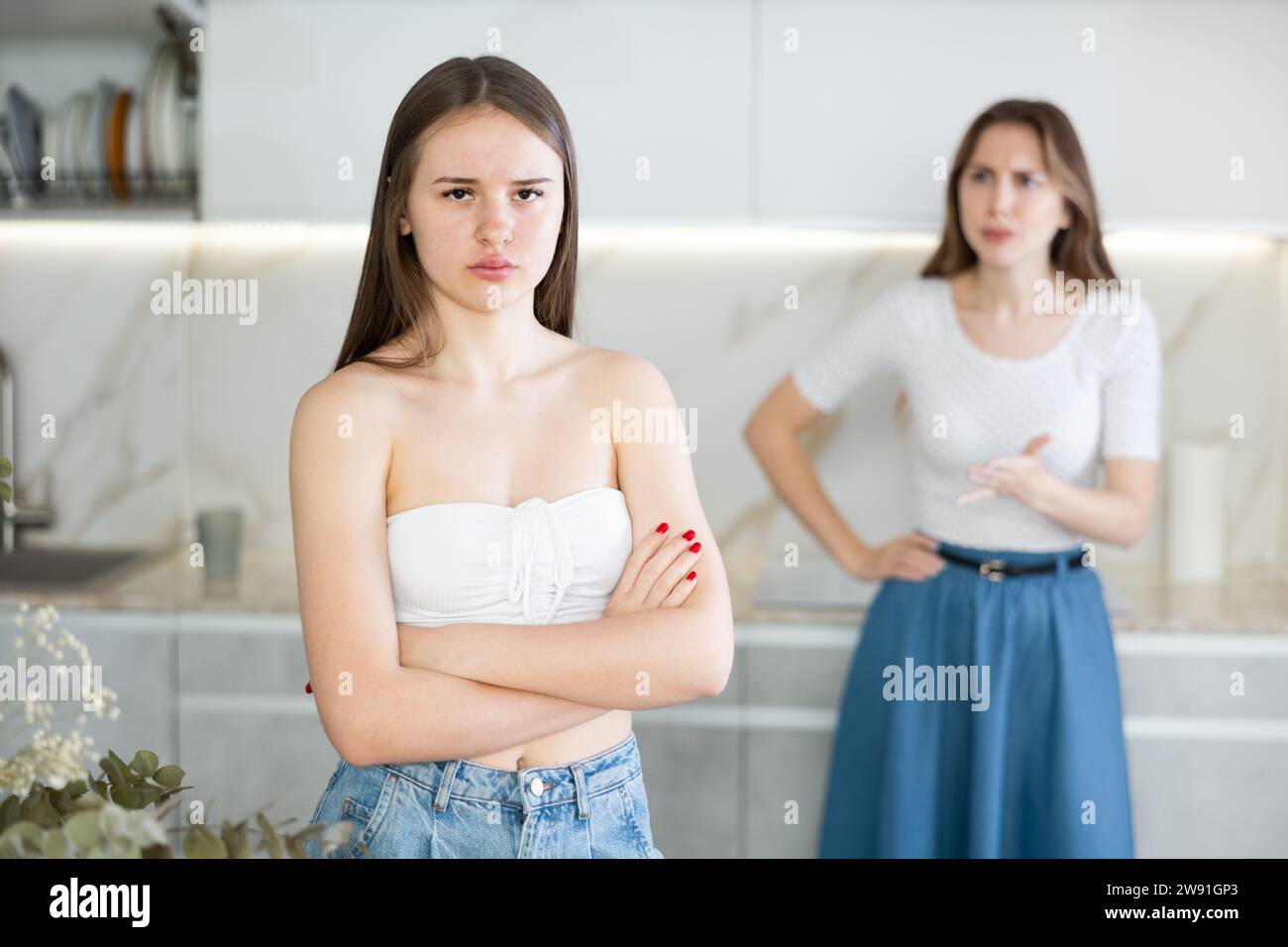 Offended young girl standing in the kitchen, angry mother talking Stock ...
