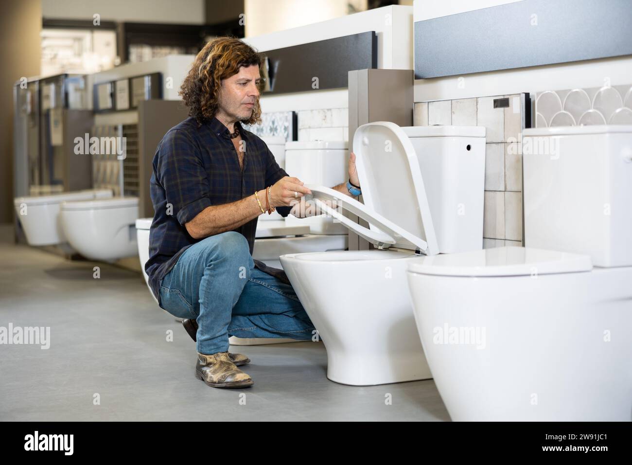 in plumbing department, male buyer checks for defects of toilet before ...