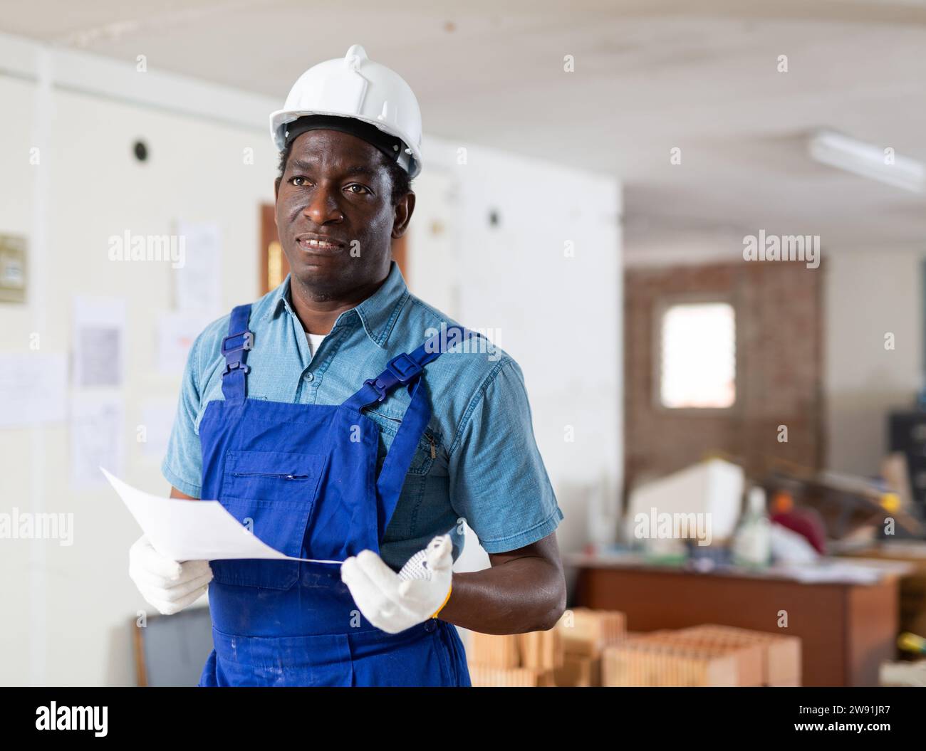 Man construction worker with document inside apartment Stock Photo - Alamy