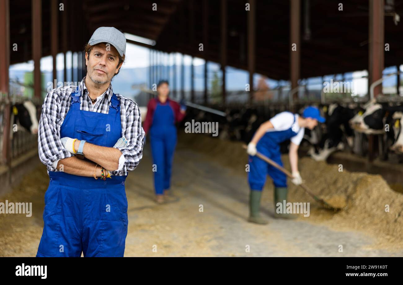 Portrait of positive male farm worker in cowshed Stock Photo - Alamy