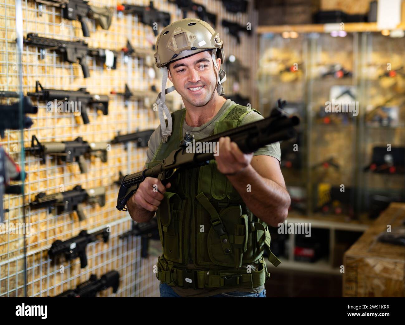 Guy in military equipment with weapon in army shop Stock Photo - Alamy