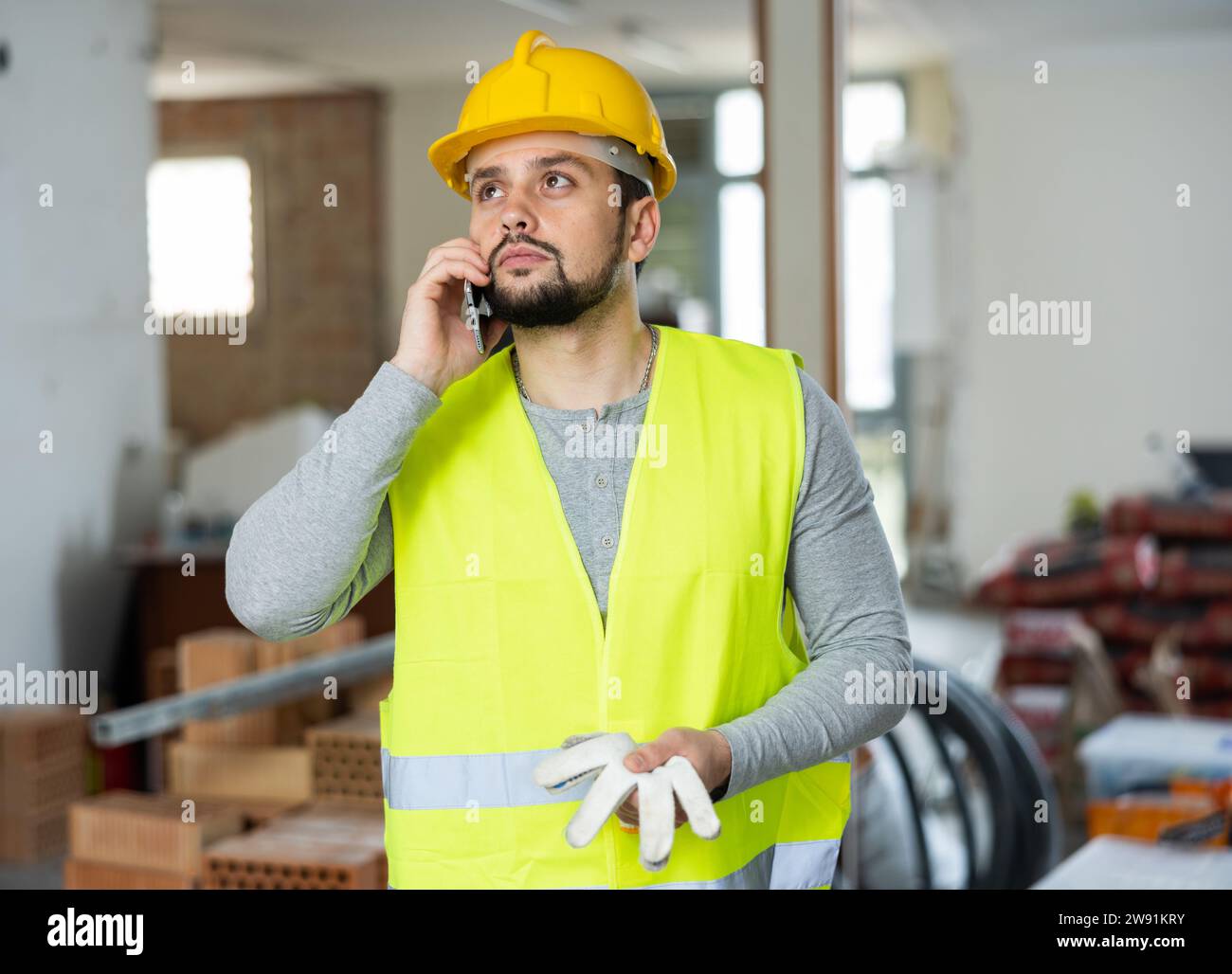 Builder talking on phone at construction site Stock Photo - Alamy