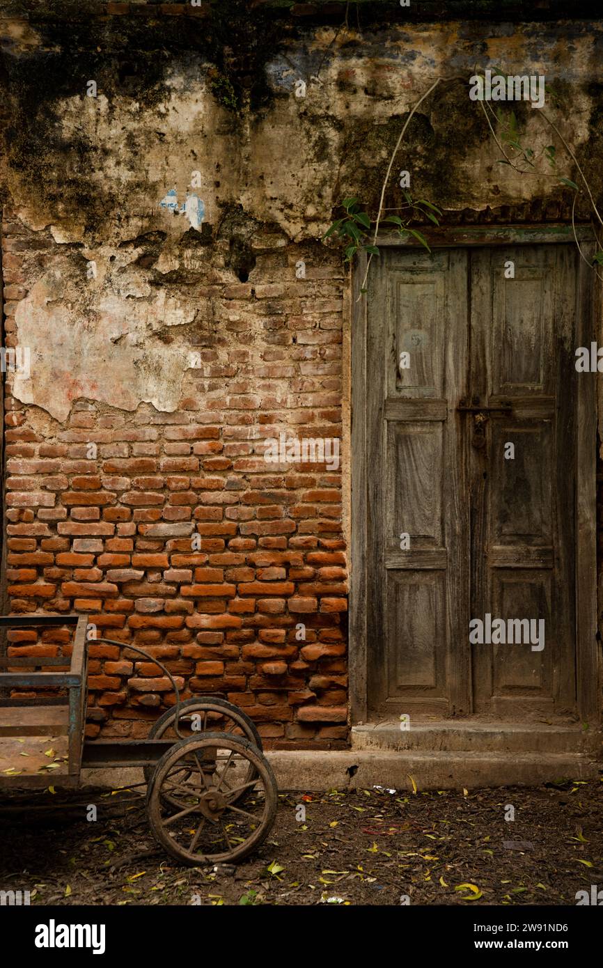 A rustic wooden door set within a timeworn brick wall. The door is ...