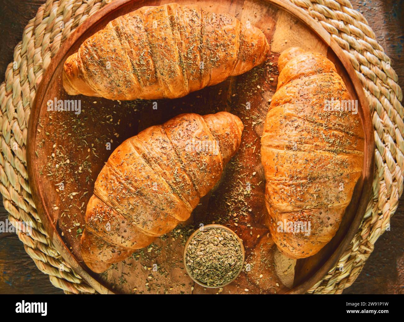 Delicious fresh baking croissant with thyme on top. Top view with close ...