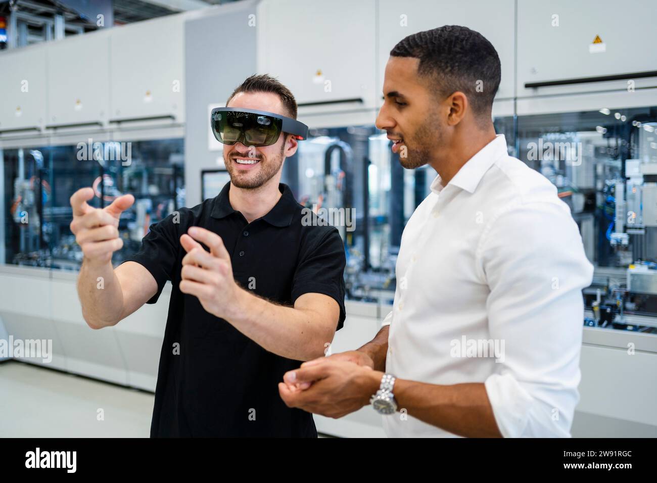 Technician wearing augmented reality glasses in a factory interacting ...