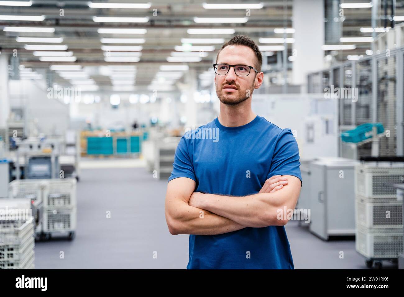Employee standing in shop floor with arms crossed hi-res stock ...
