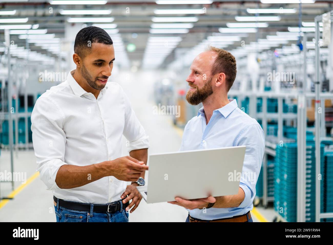 Two businessmen with laptop having a meeting in a factory Stock Photo ...