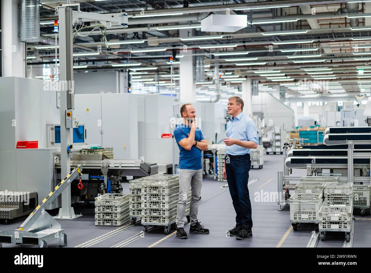 Employee and businessman talking in a factory Stock Photo - Alamy