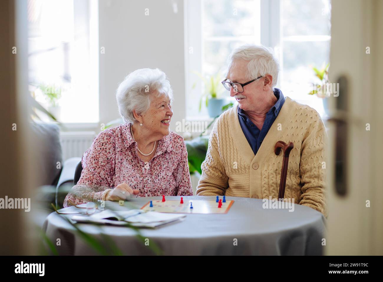 Smiling senior woman playing ludo game with man at home Stock Photo - Alamy