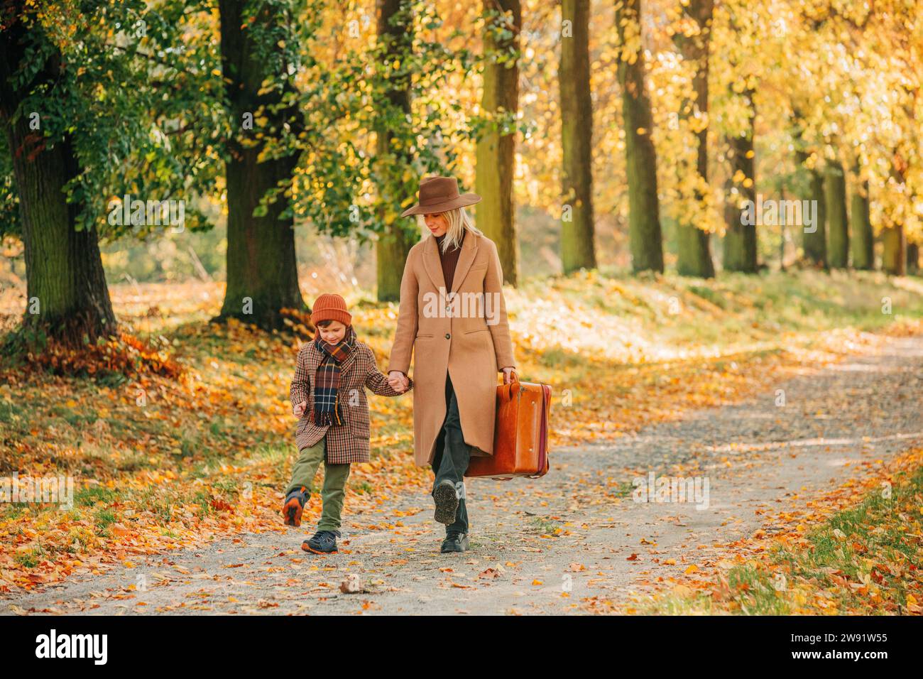 Mother holding hands with son and walking in autumn park Stock Photo ... Mother holding hands with son and walking in autumn park Stock Photo ...