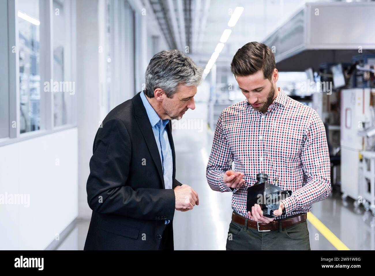 Engineers examining machine part in industry Stock Photo - Alamy