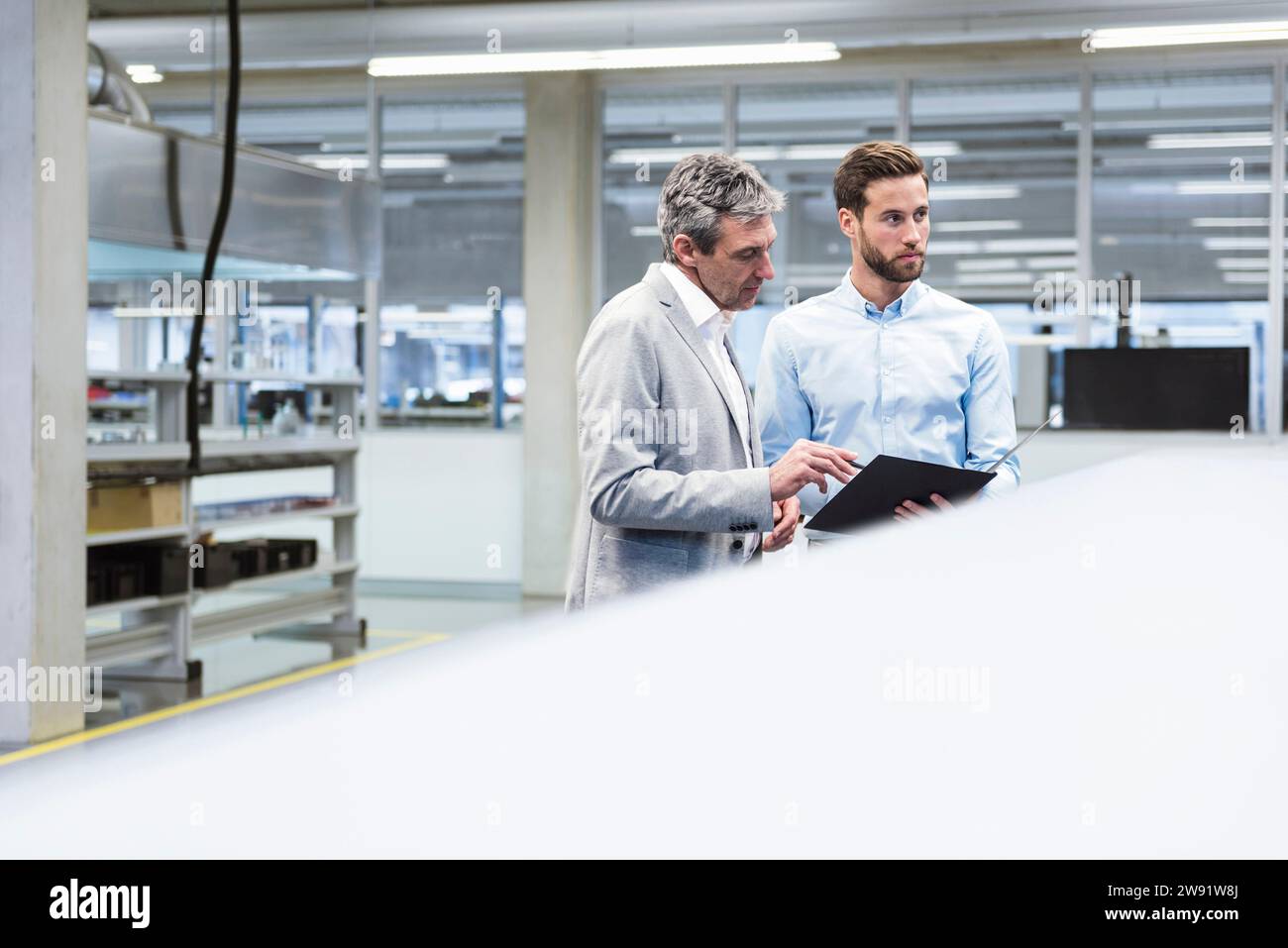 Engineers examining documents and working in factory Stock Photo - Alamy