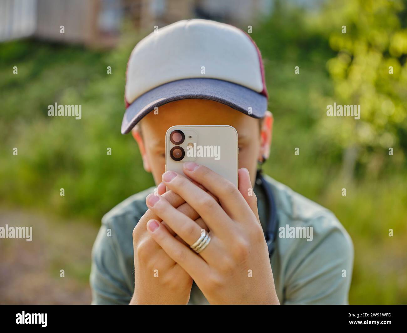 Boy taking picture with smart phone at forest Stock Photo - Alamy