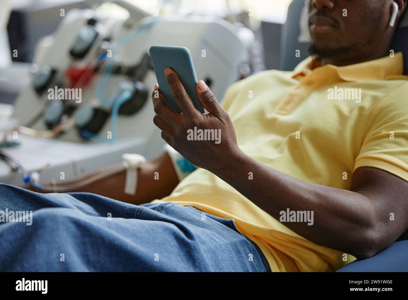 Hand of man holding mobile phone at blood donation center Stock Photo ...